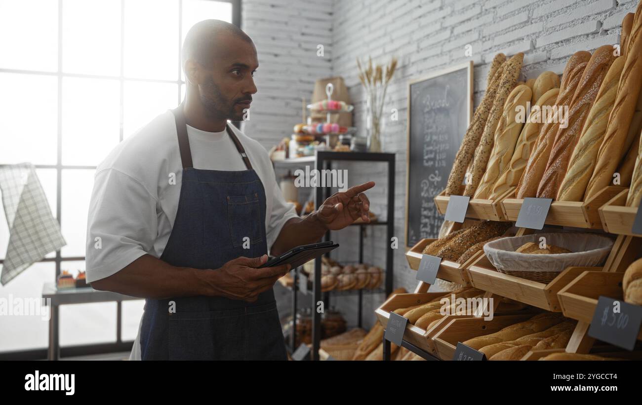 Handsome man in bakery shop examining bread display while holding ...