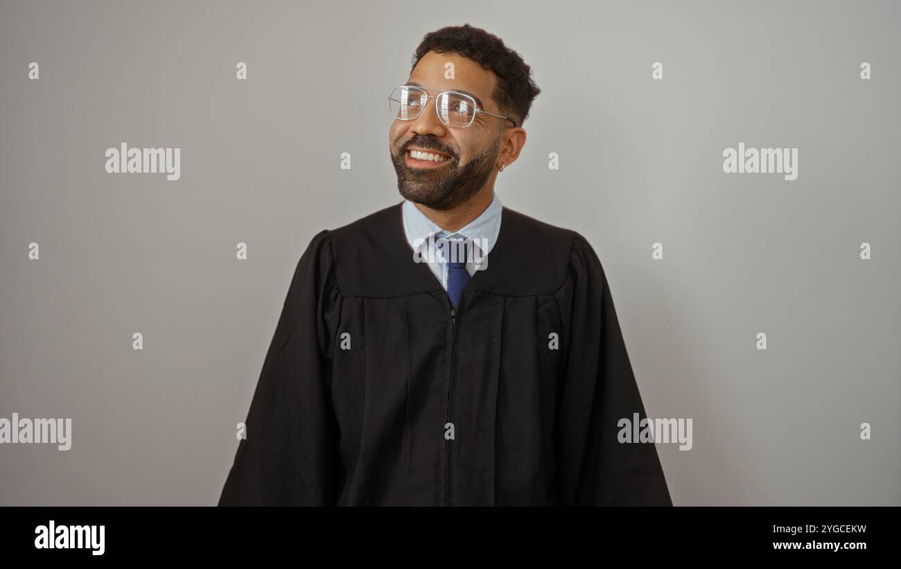 Young hispanic man wearing a graduation gown and glasses smiling over ...