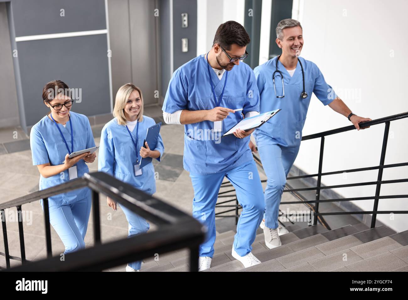 Healthcare workers walking up stairs in hospital Stock Photo - Alamy