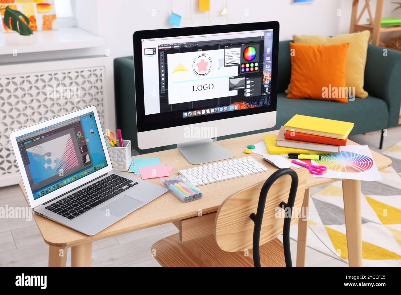 Designer's workplace with computer, laptop, color palette and ...