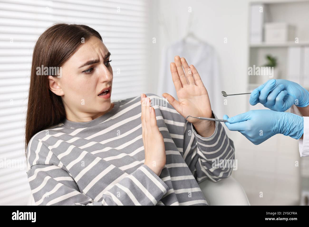 Dental phobia. Dentist working with scared woman in clinic, closeup ...