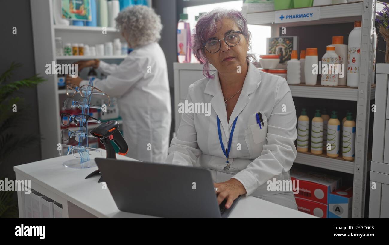 Two middle-aged women pharmacists working together in a pharmacy store ...