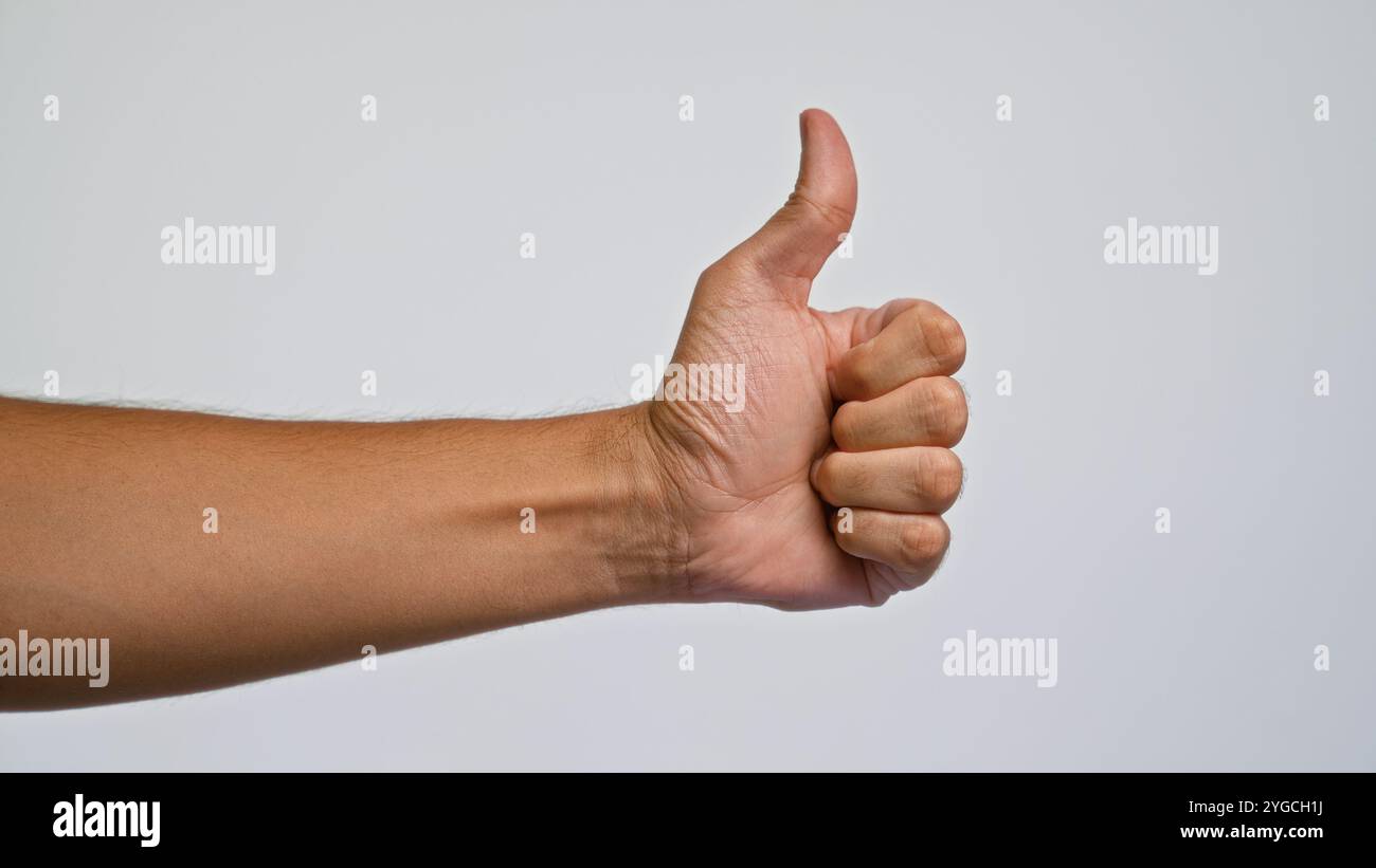 Man's hand giving a thumbs up against a plain white background ...