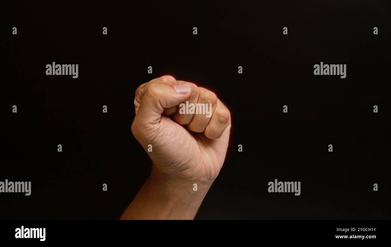 Man fist isolated against a dark background signifies strength ...