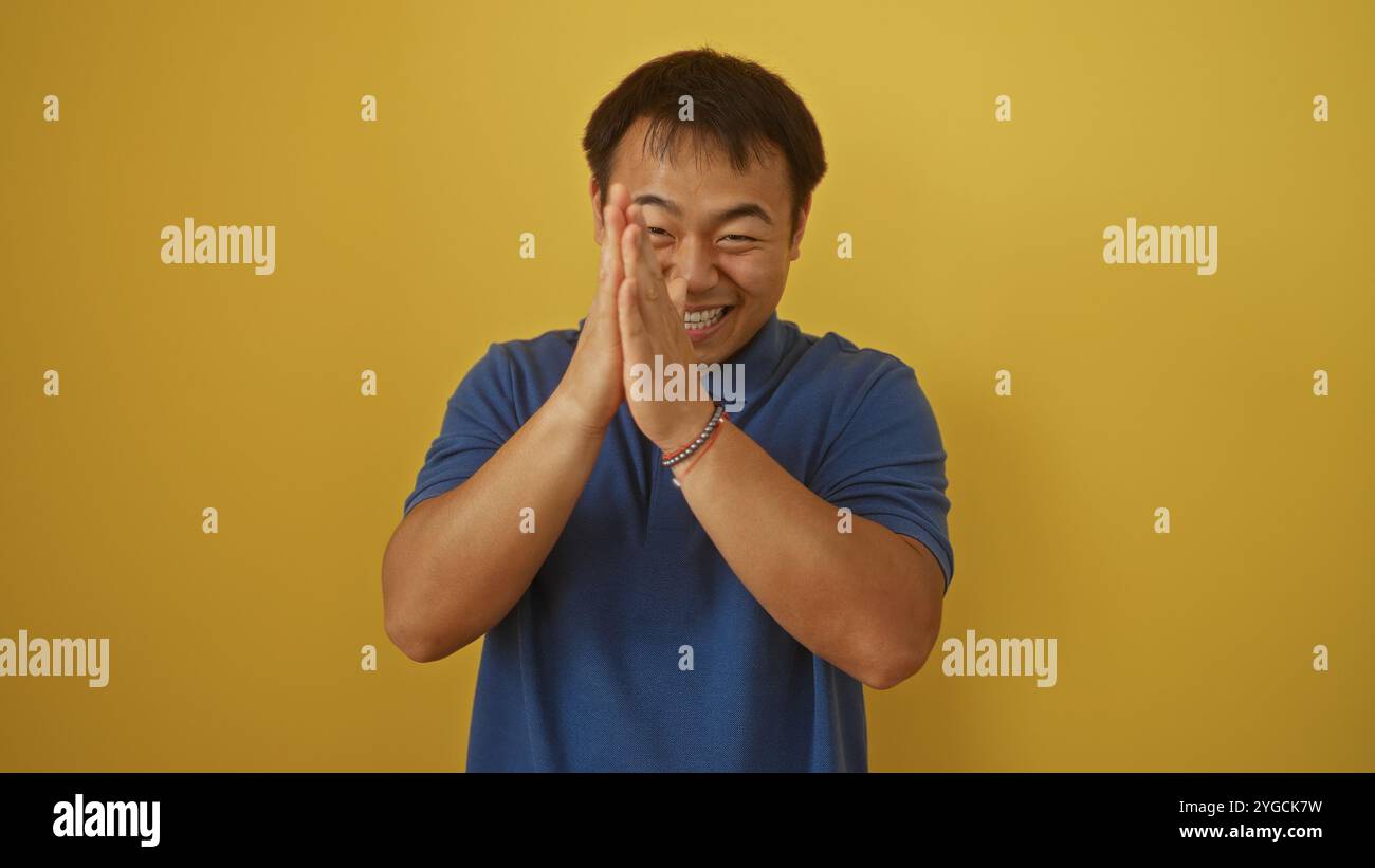 Handsome chinese man smiling and clapping his hands isolated over a ...