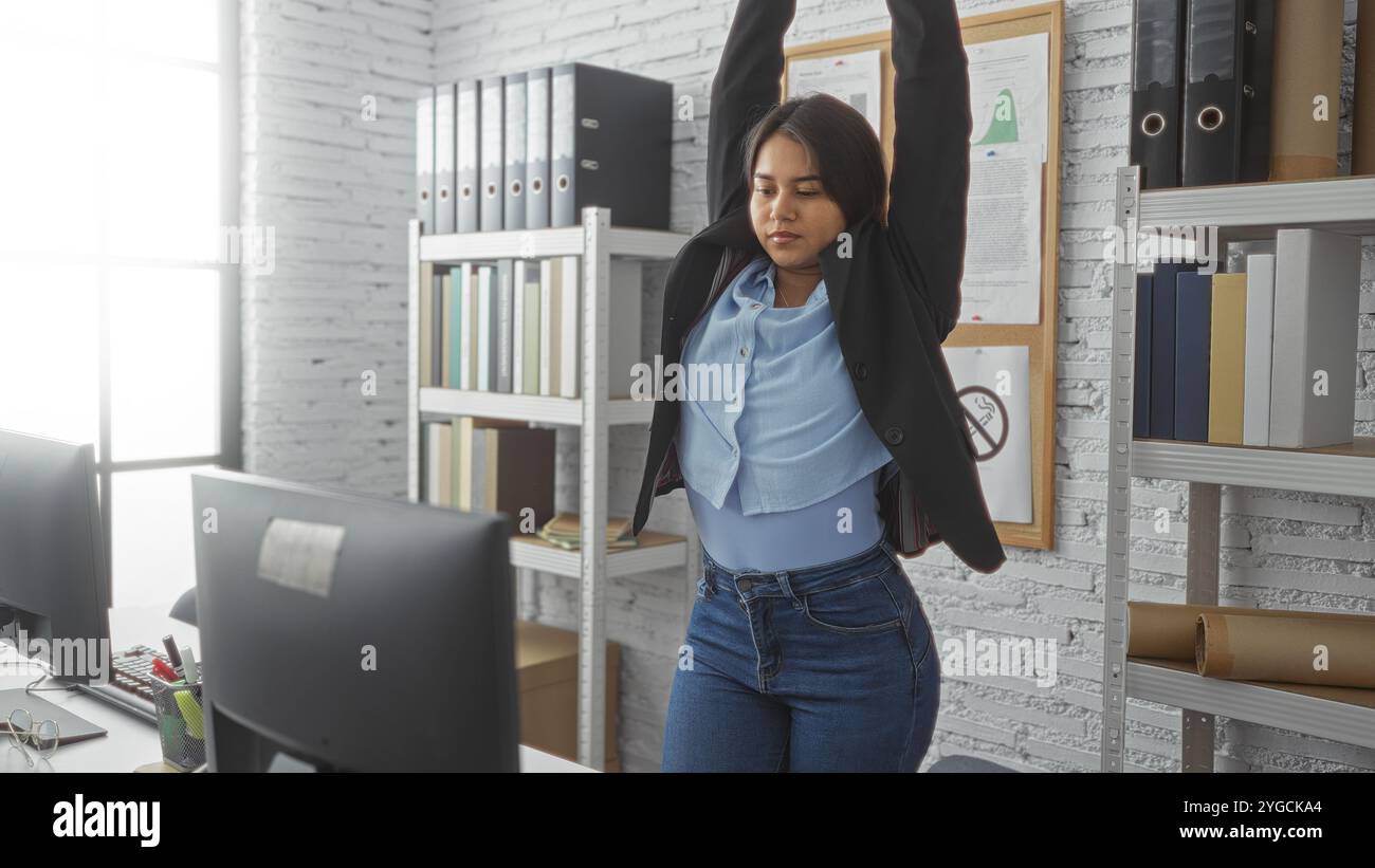 Woman stretching in an office surrounded by bookshelves and desks with ...