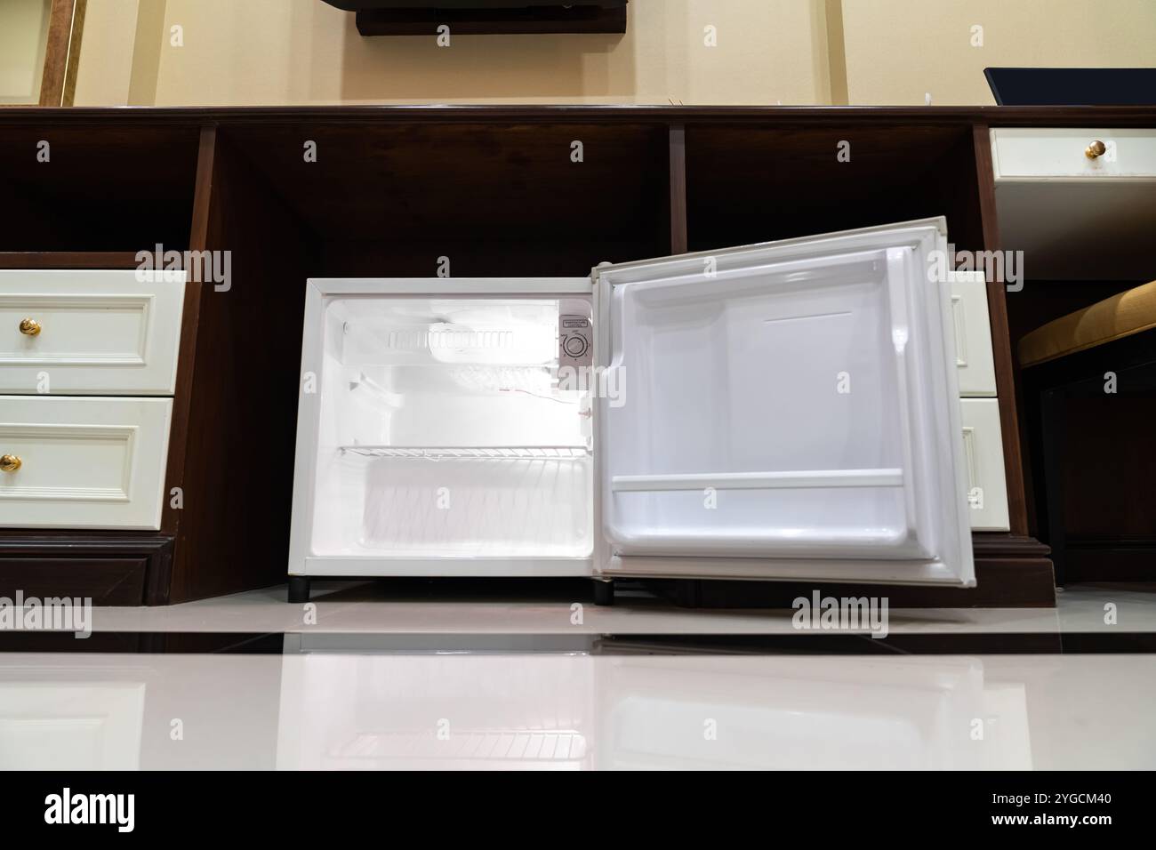 mini fridge in low angle view, inside it’s empty shelves placed under ...