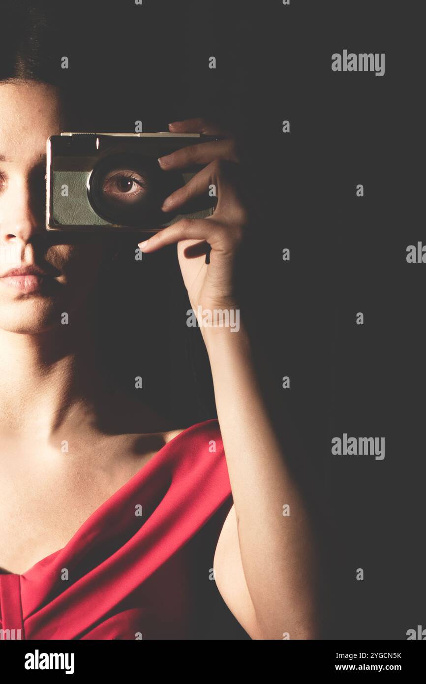 person with camera framing with the lens covered by her eye, concept of ...