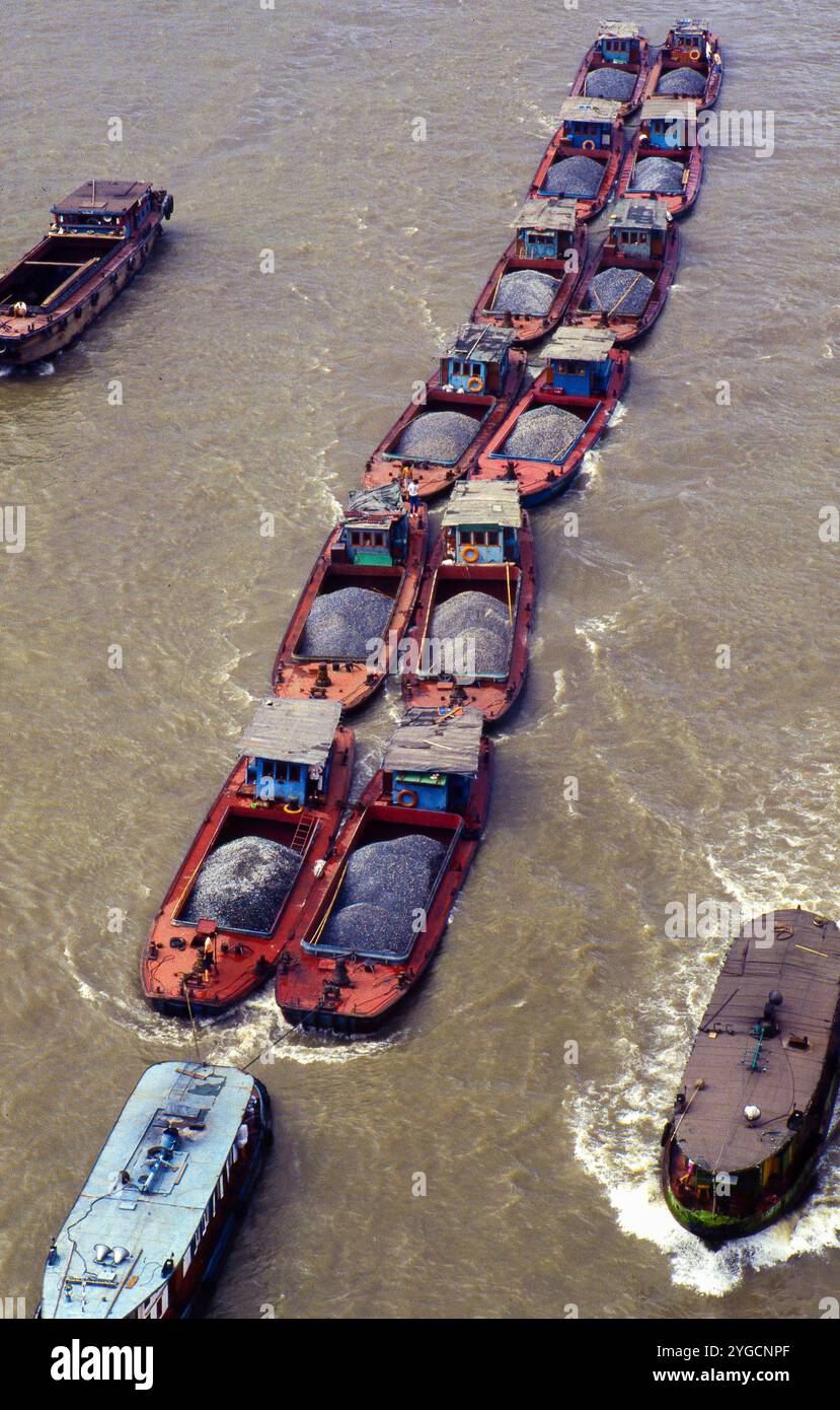 China, Shanghai, a boat pulls 12 barges with gravel on the Huangpu ...
