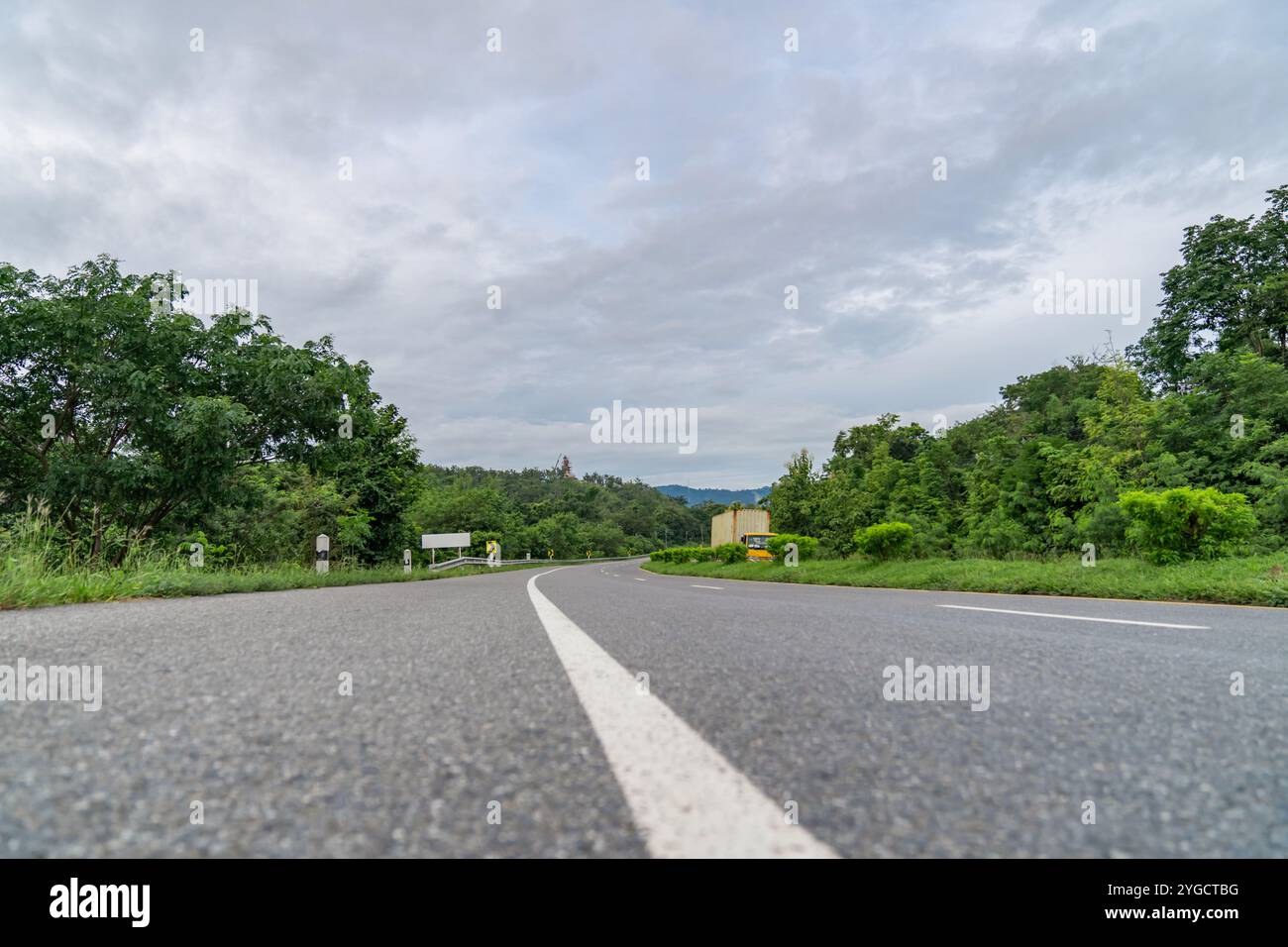 A ground-level perspective of a rural street in Tak Province, Thailand ...