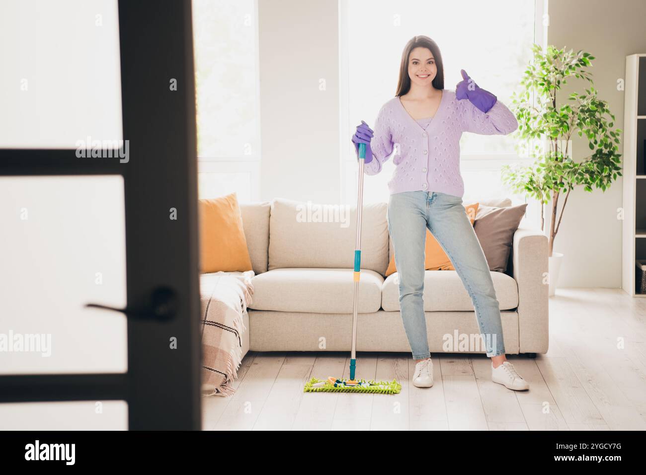 Full size photo of attractive young teen woman mopping floor thumb up ...