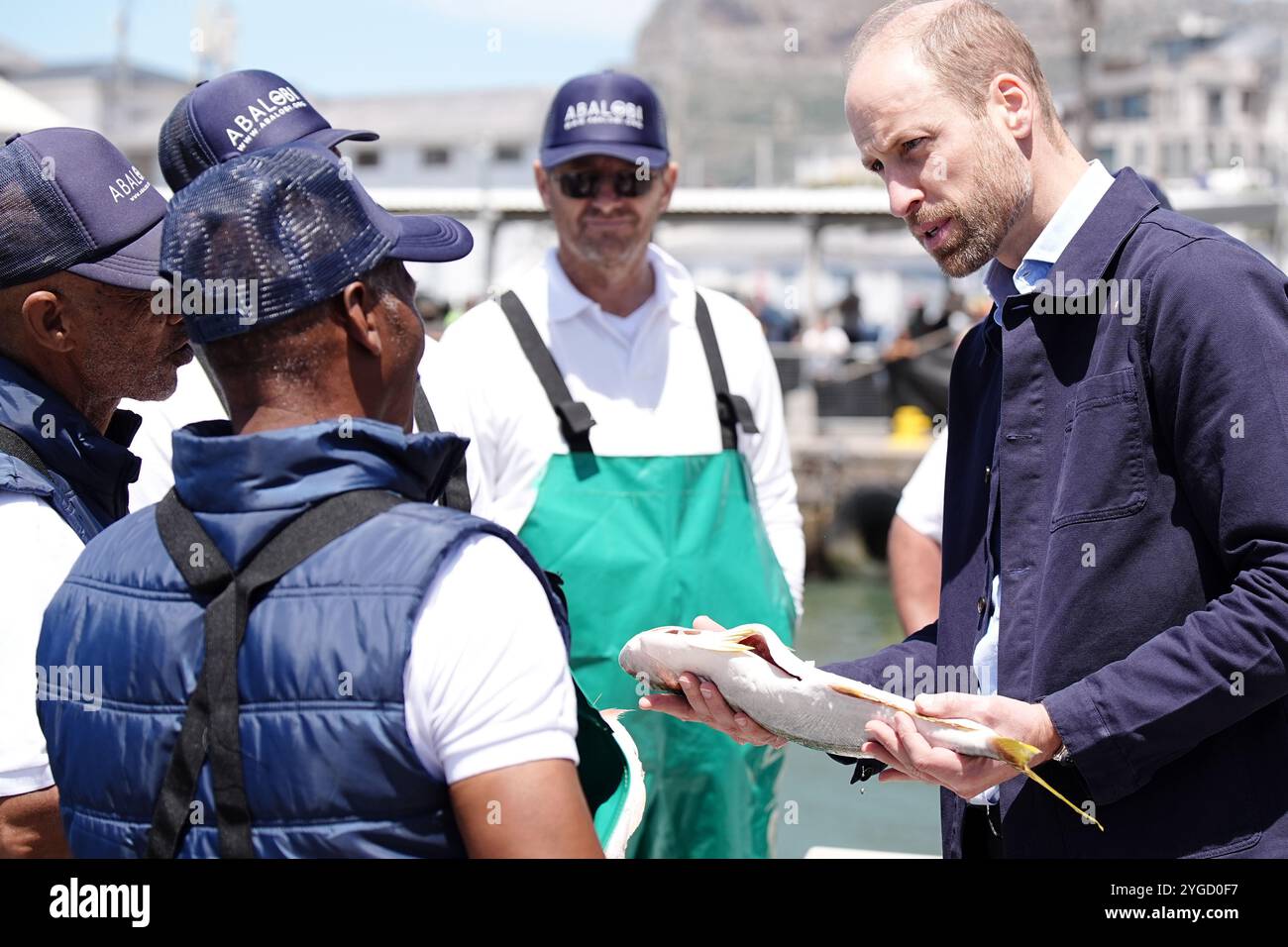 The Prince of Wales holds a yellowfin tuna fish, while meeting local ...