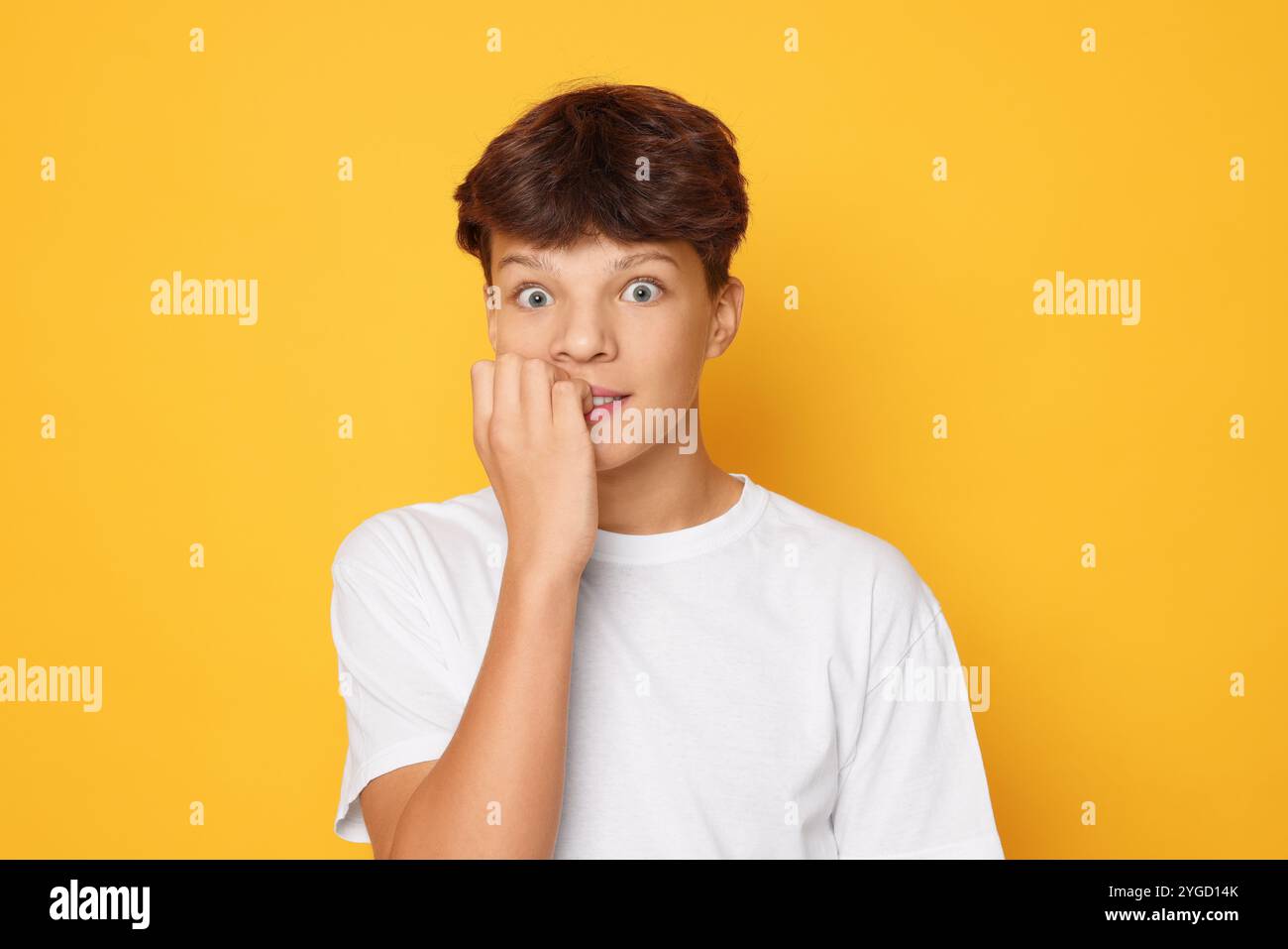 Portrait of scared teenage boy on orange background Stock Photo - Alamy
