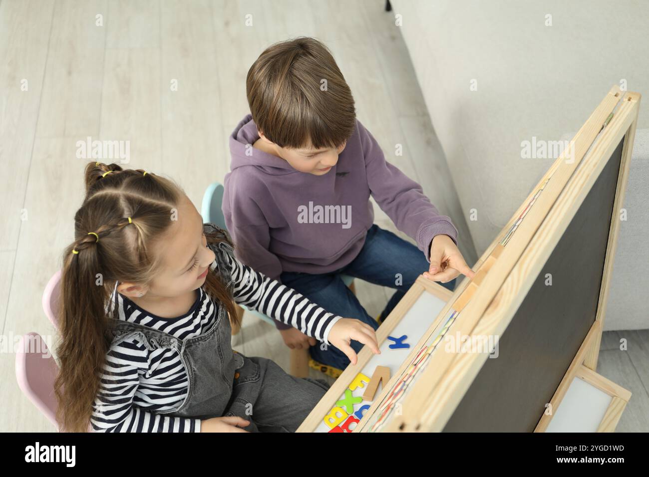 Little kids learning alphabet with different letters on board indoors ...