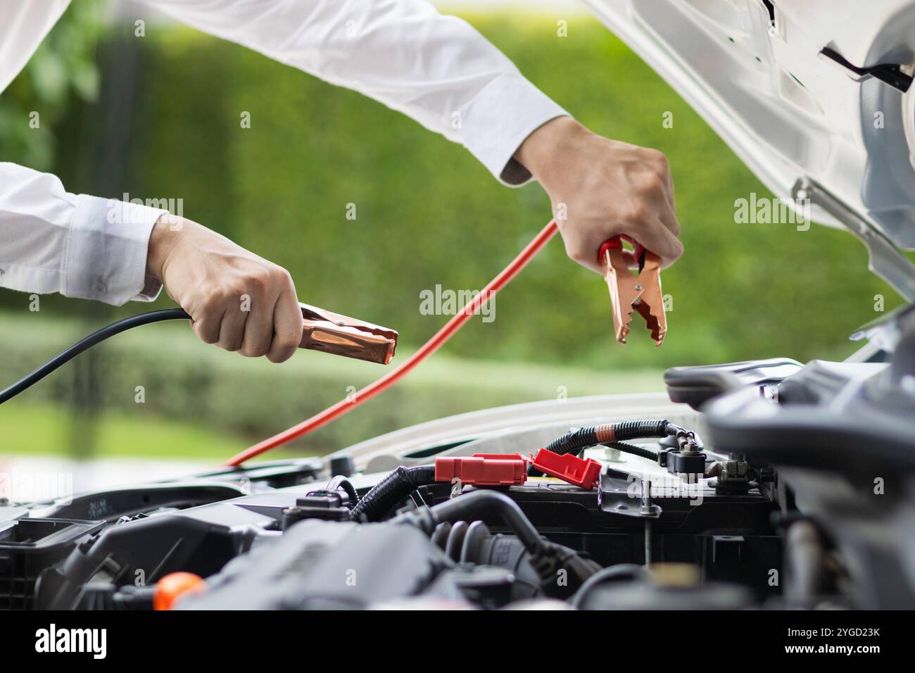 mechanic from the service center is helping to jump start the car ...