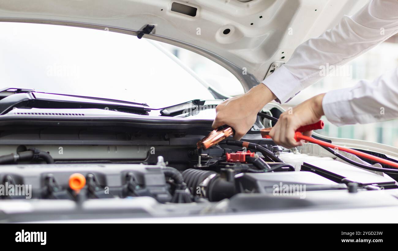 mechanic from the service center is helping to jump start the car ...