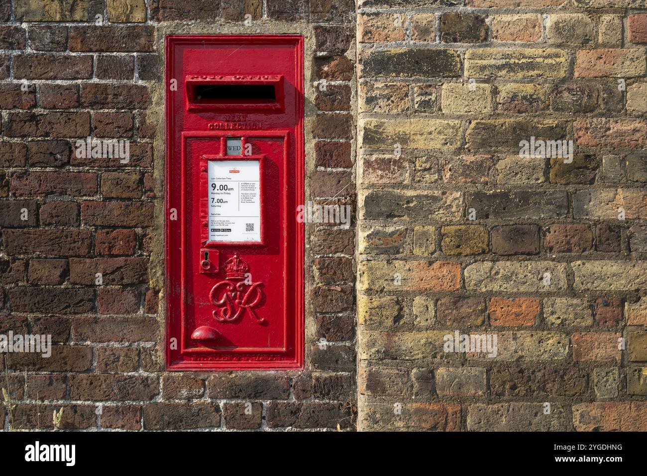Red letterbox built into a brick wall, typical of urban England, Kew ...