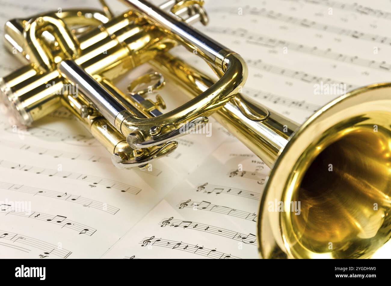 Golden trumpet lying on sheet music Stock Photo - Alamy