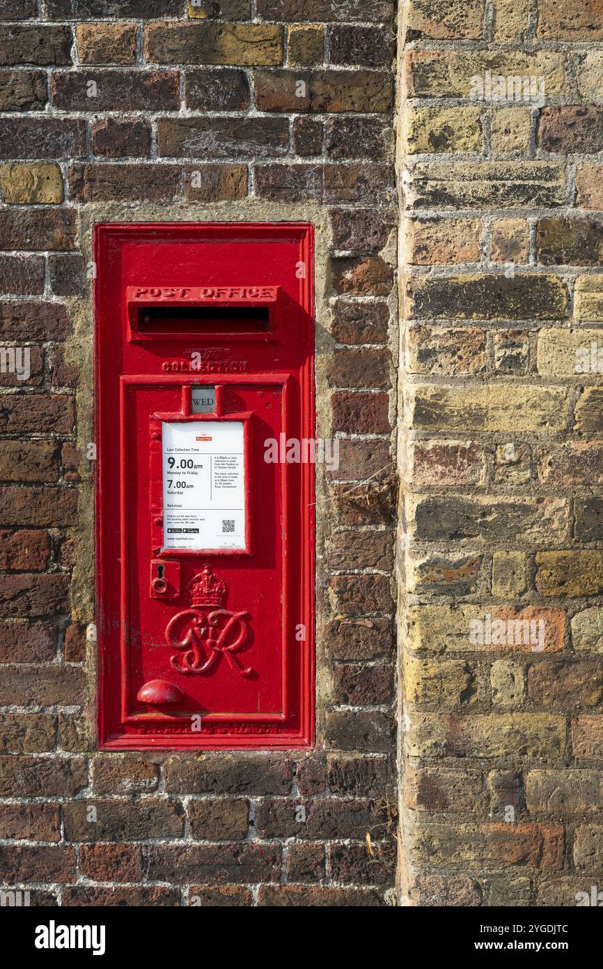 Red letterbox built into a brick wall, typical of urban England, Kew ...