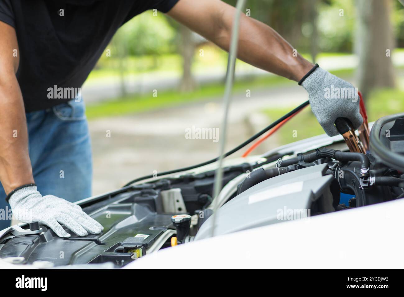 mechanic from the service center is helping to jump start the car ...