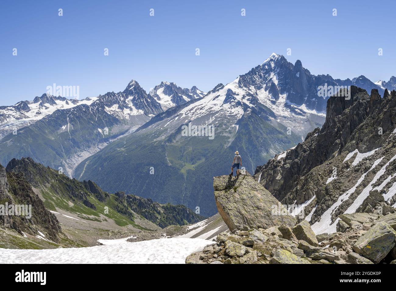 Mountaineer standing on a rock, mountain landscape with mountain peak ...
