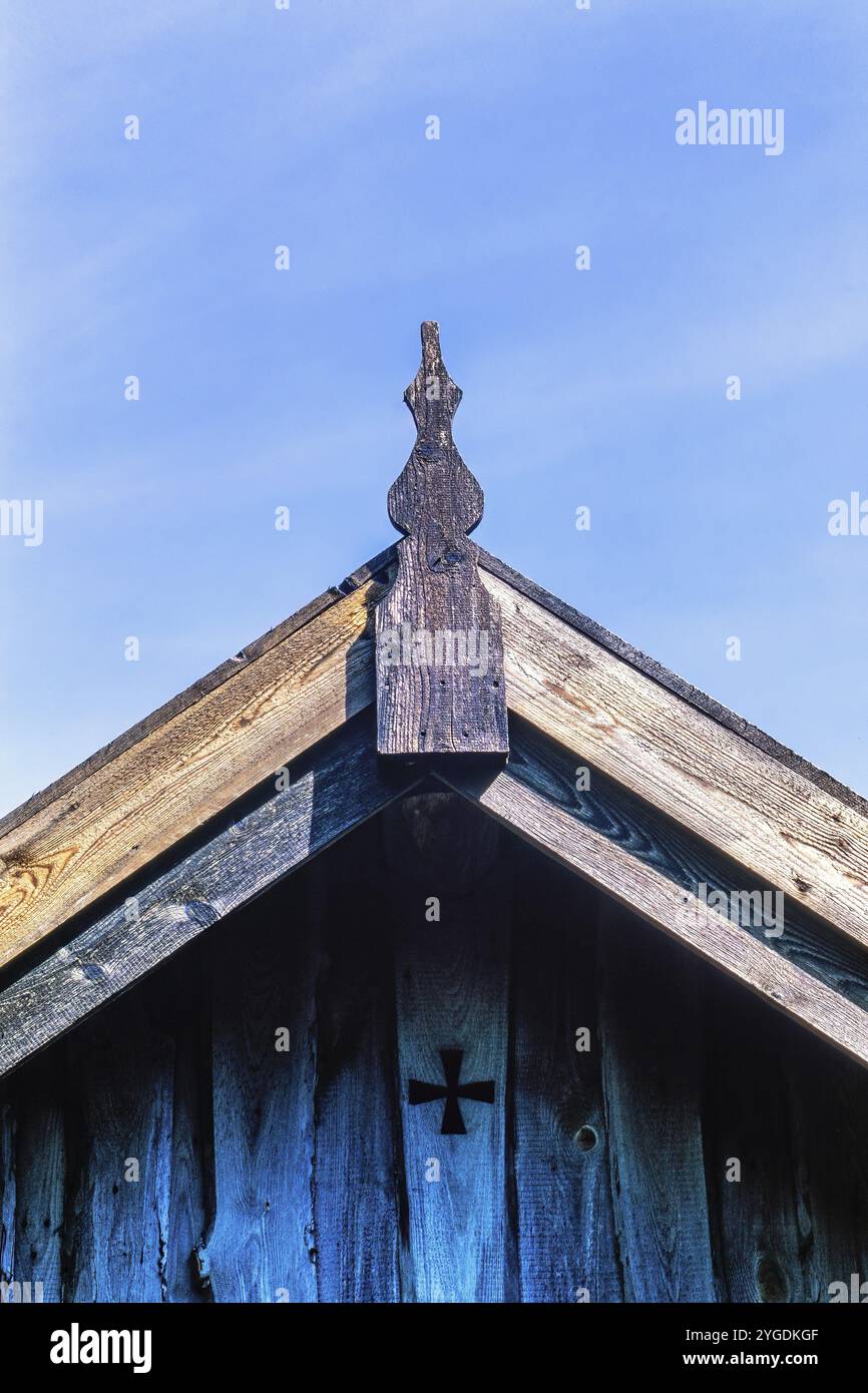 Gable and the rooftop on an old wooden cottage with a cross on the wall ...