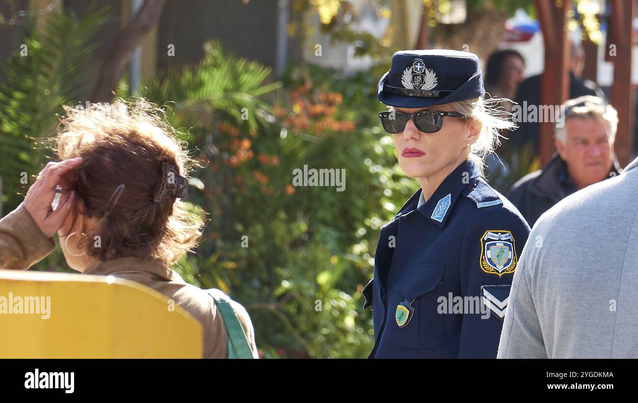 Greek police officer in uniform and sunglasses stands in a talkative ...