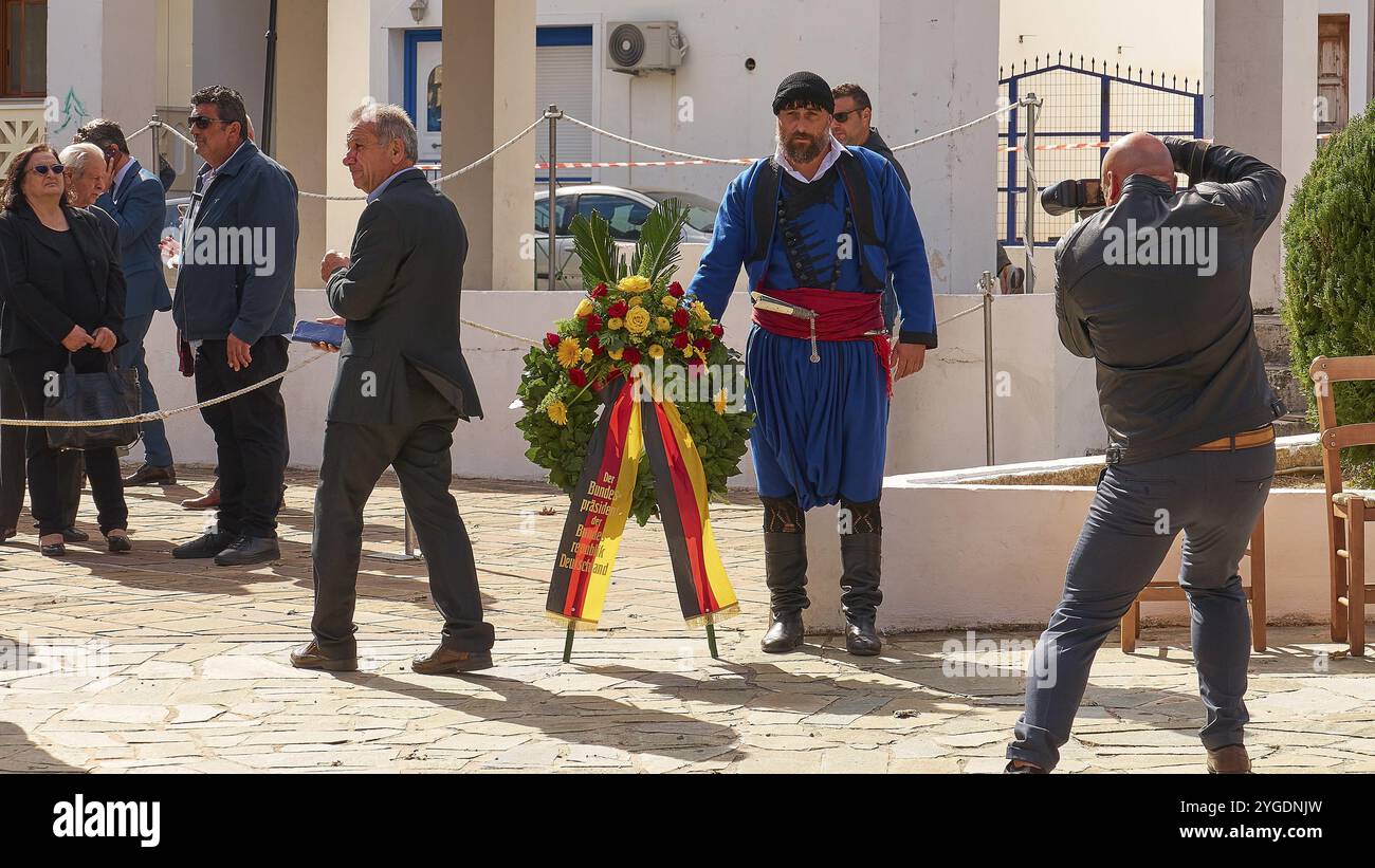 A man in traditional Cretan traditional costume carries a wreath at a ...