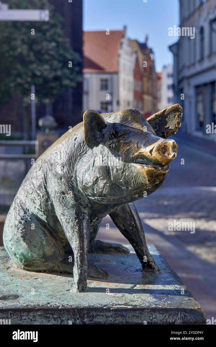 Bronze sculpture of a wild boar on a pedestal in front of a city ...