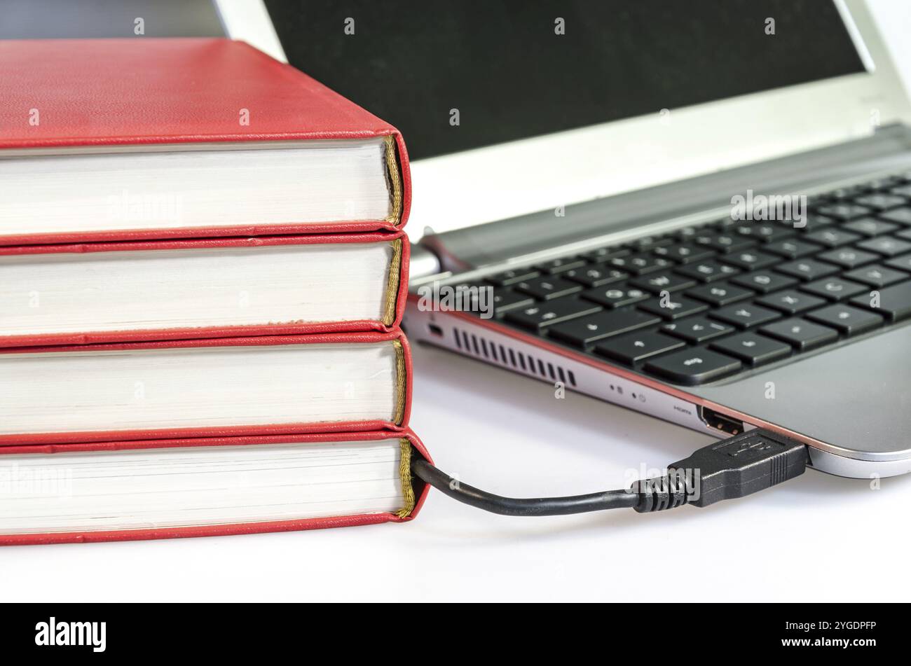 Pile of books connected to a laptop Stock Photo - Alamy