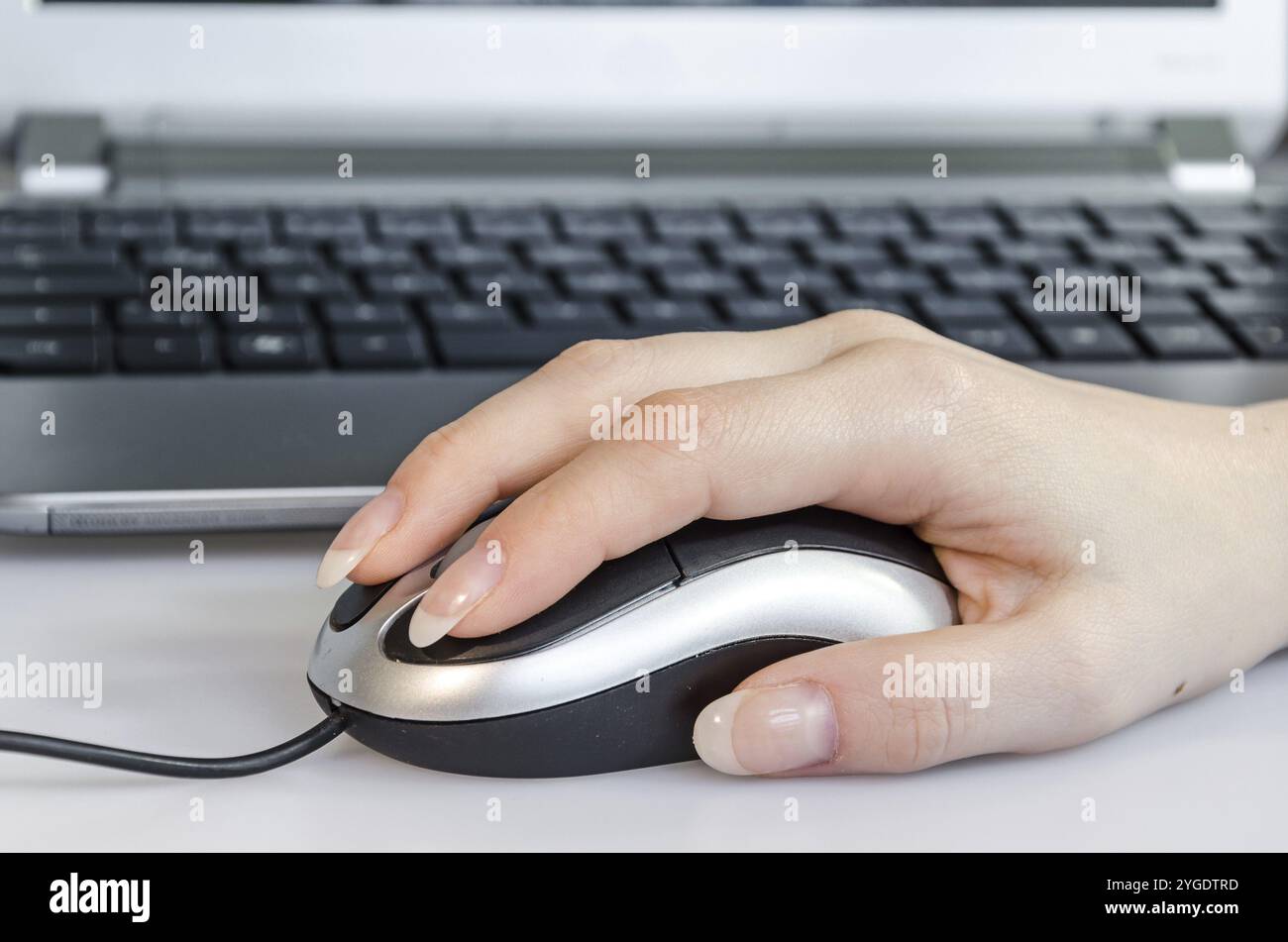 Female hand using computer mouse in front of laptop Stock Photo - Alamy
