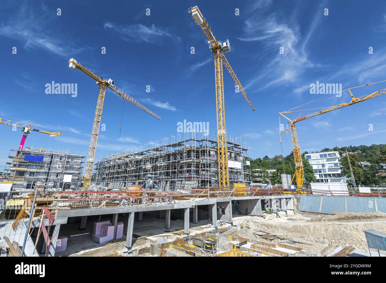Large building site with foundations, cranes, scaffolding and partly ...