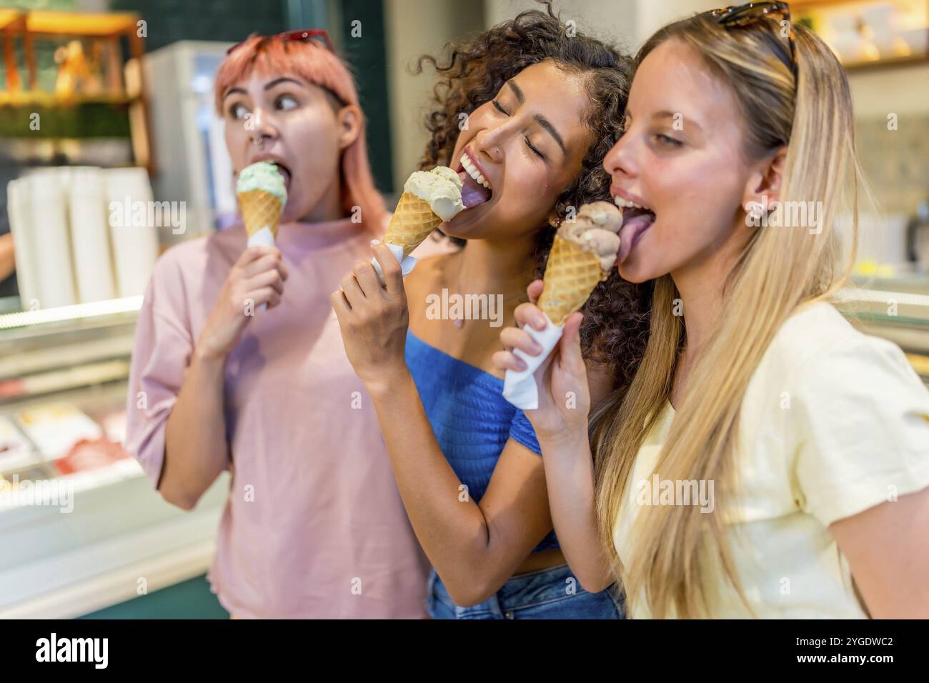 Three diverse women licking a delicious ice cream cone in a store Stock ...