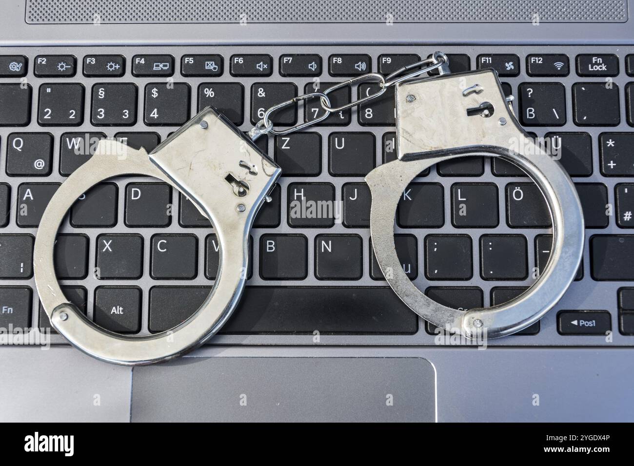 Handcuffs lying on a computer keyboard symbolizing cyber crime Stock ...