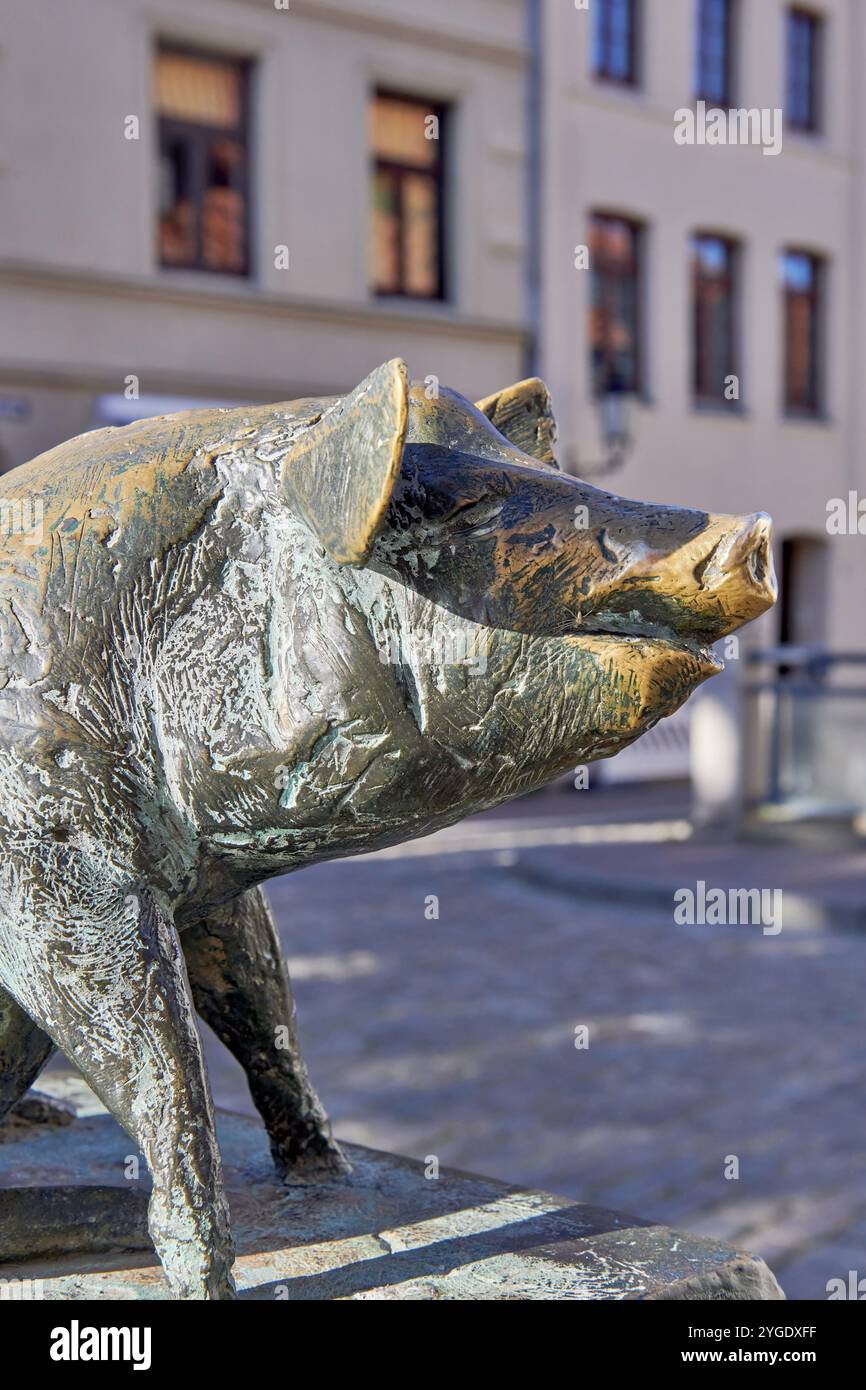 Bronze sculpture of a wild boar on a plinth by a road, pig bridge with ...