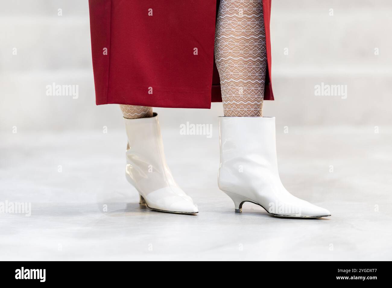 Pair of white boots with pointed toe and small heel on legs of woman in ...