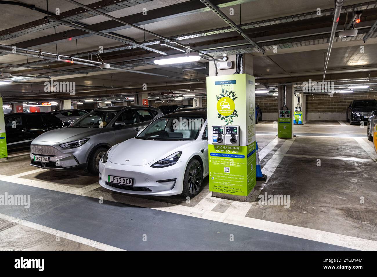 Oxford , UK - June 5, 2024: Tesla charging in underground car park full ...