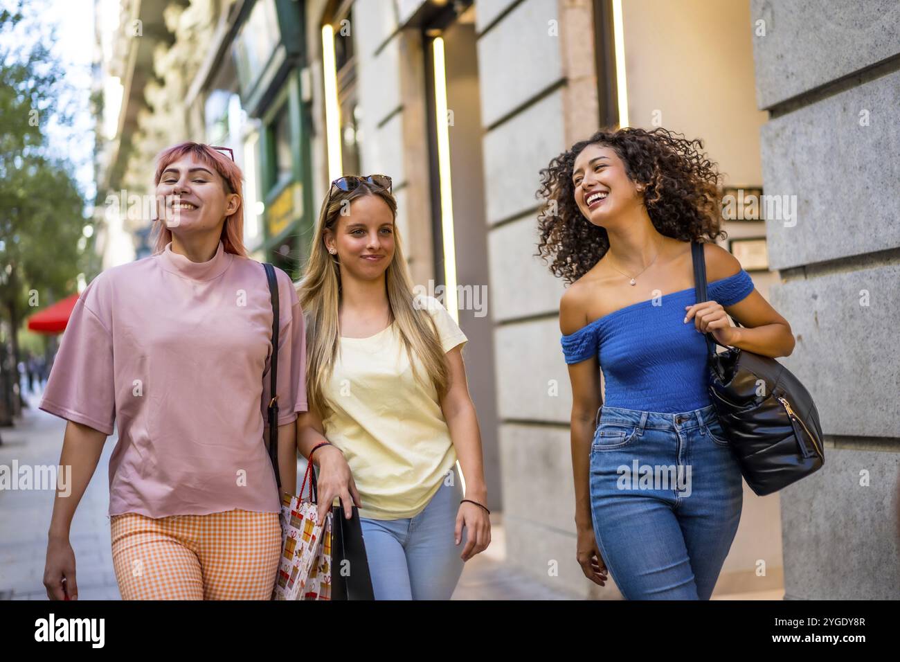 Happy diverse women walking and shopping along a modern city Stock ...