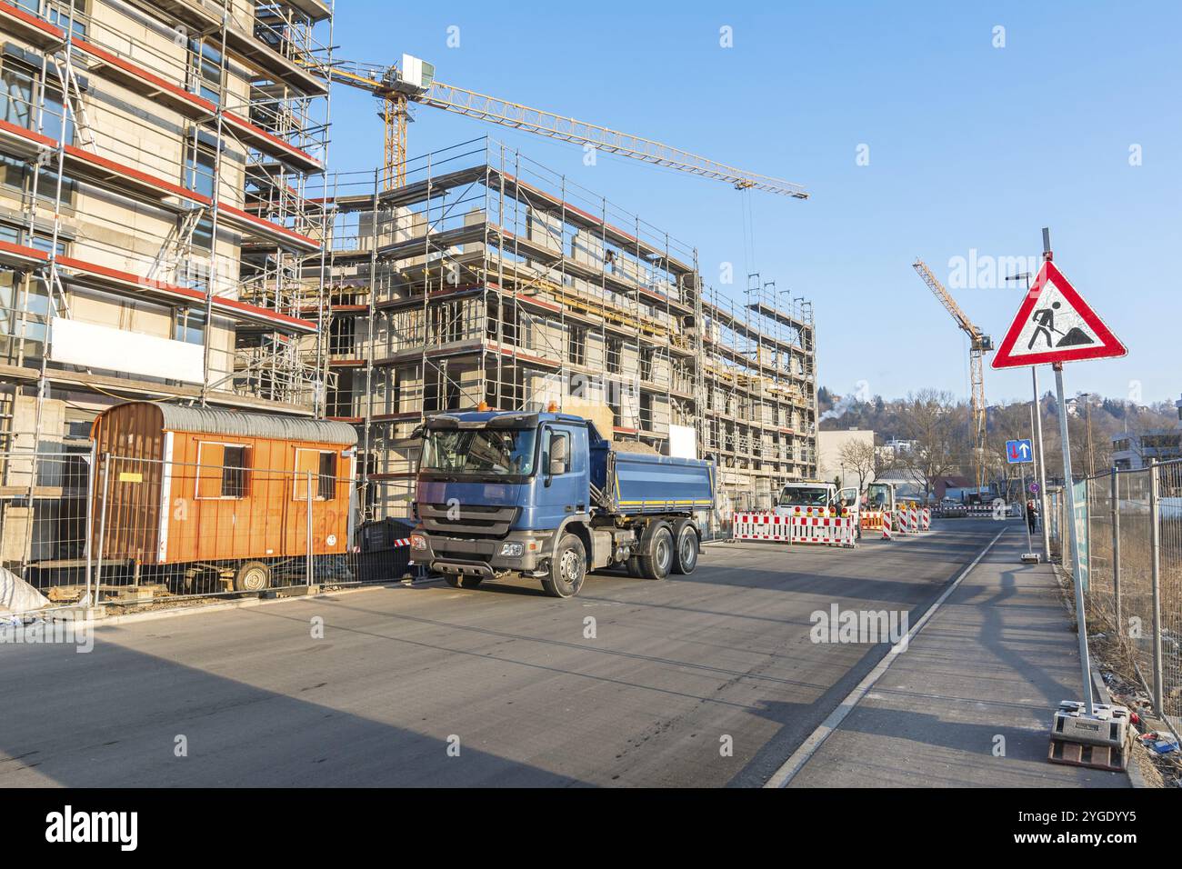 Unfinished apartment building with construction vehicles, scaffolding ...