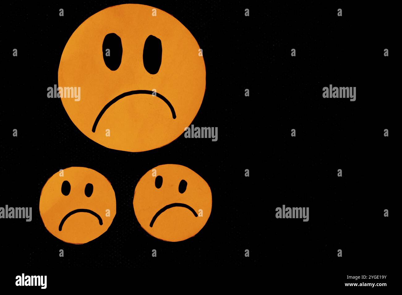 Sad orange emoticons on black background concept of dissatisfaction ...