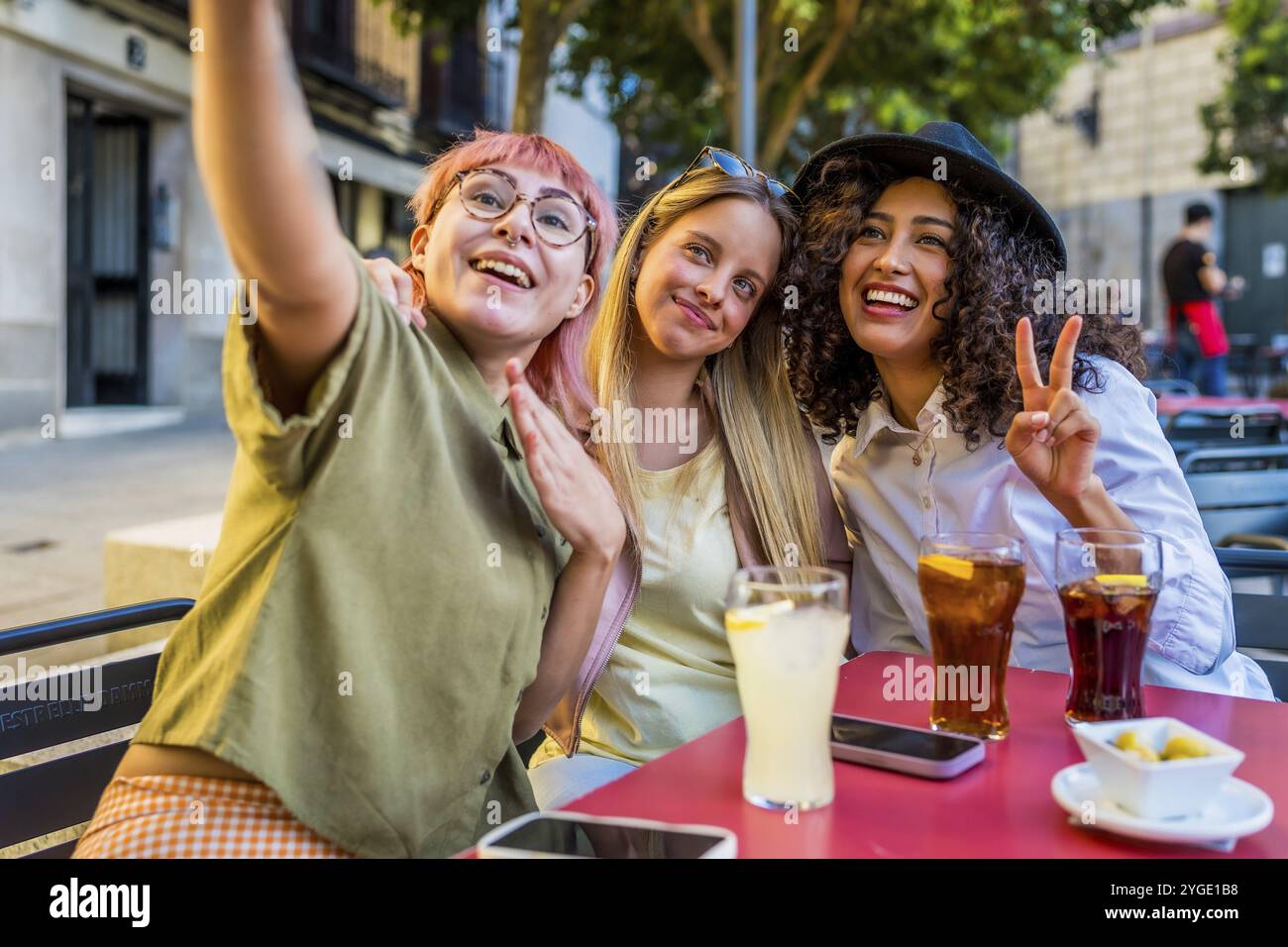 Happy latin and caucasian women taking selfie and gesturing success in ...