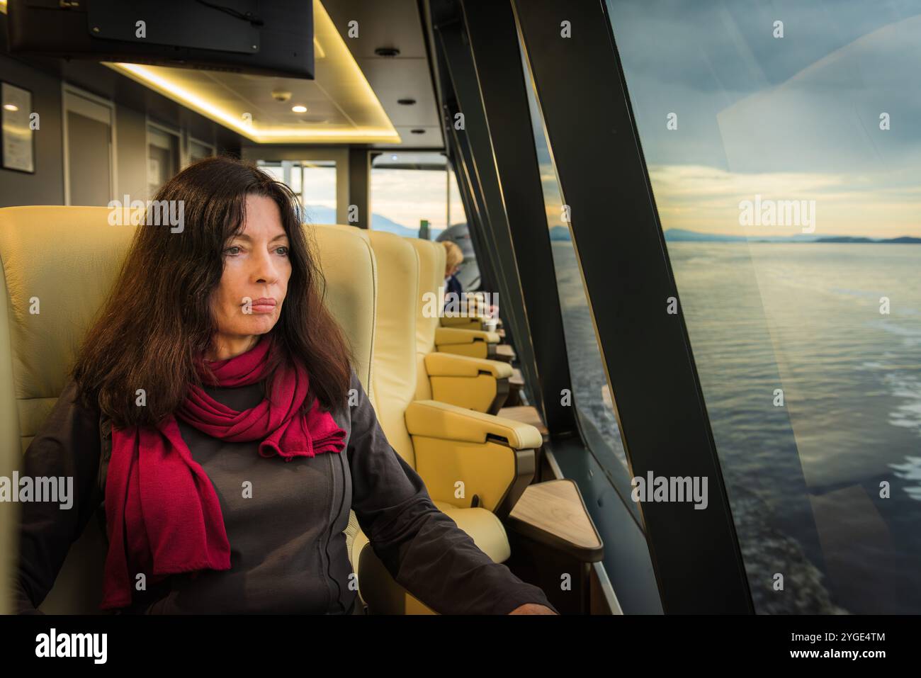 A single female tourist sits on a plush armchair angled outward and ...