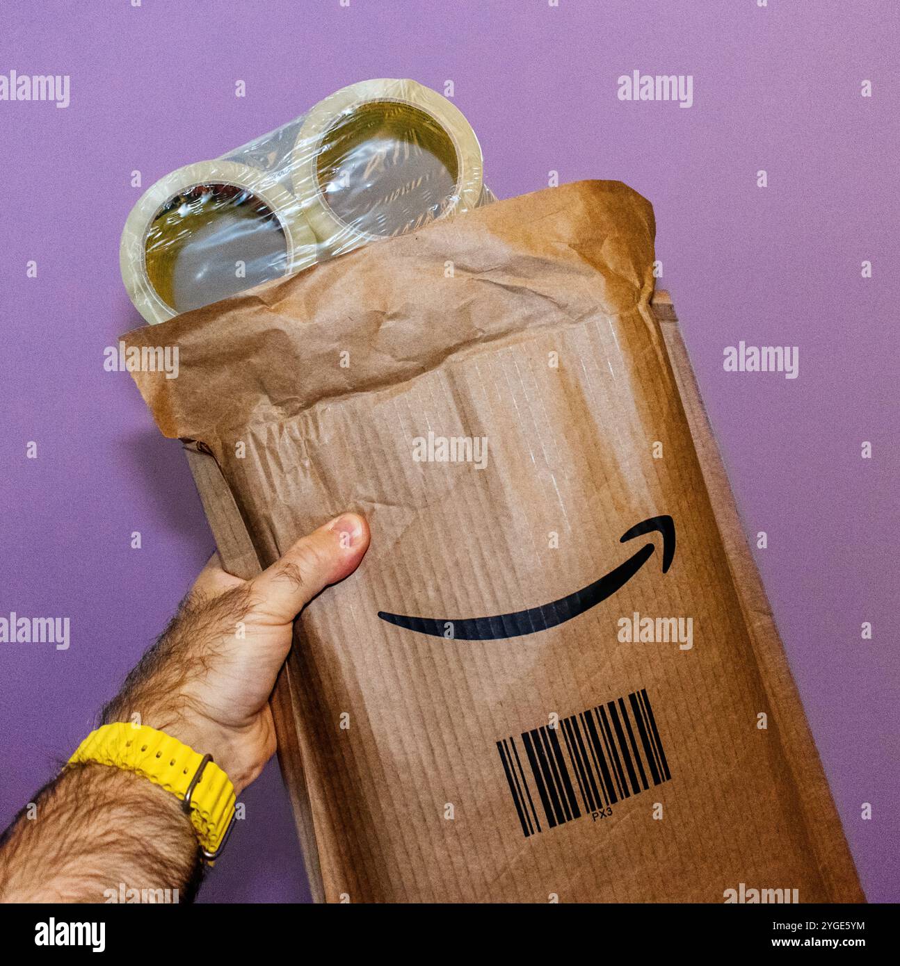 Paris, France - Nov 6, 2024: A hand holds an Amazon package partially ...