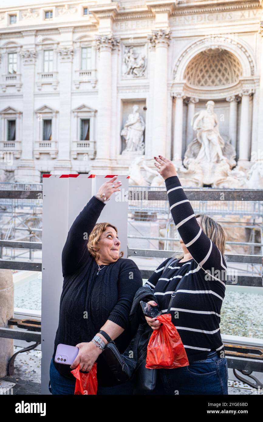 Rome, Italy. 06th Nov, 2024. Tourists throw a coin into the Trevi ...