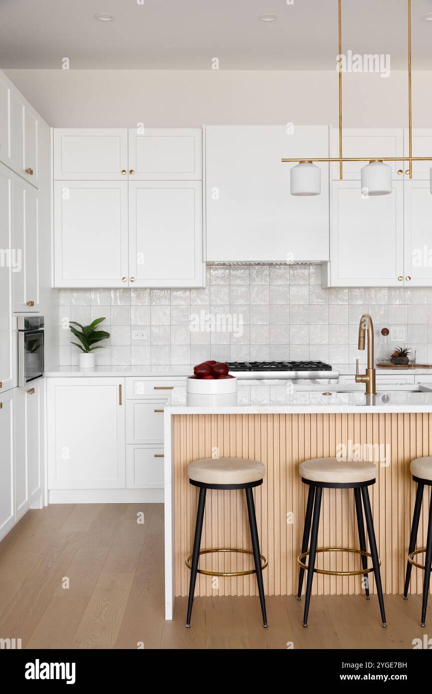 A kitchen detail with white cabinets and square tile backsplash, a ...