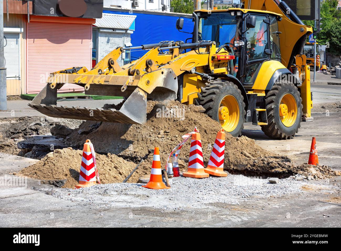 Construction workers using heavy machinery to repair urban road during ...