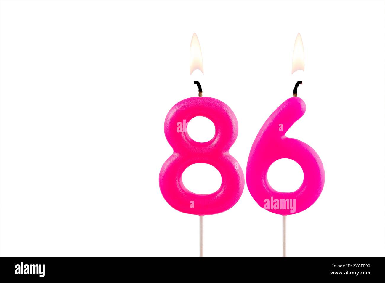 Pink number 86 birthday candle lit on white background Stock Photo - Alamy