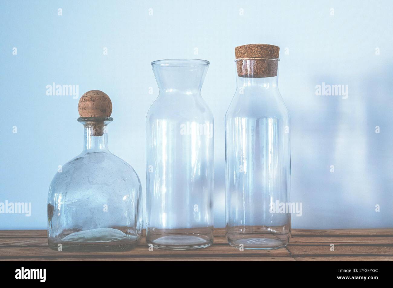 Three glass bottles of different shapes on a white background. Empty ...