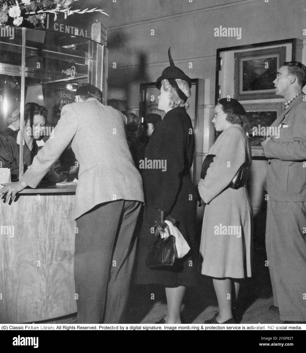 At the cinema in the 1940s. People in front of the cashier to buy tickets to the film. *** Local ...