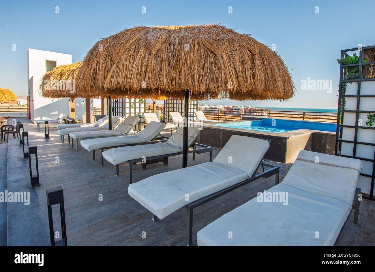 Roof terrace area with sun beds and swimming pool on top of luxury ...